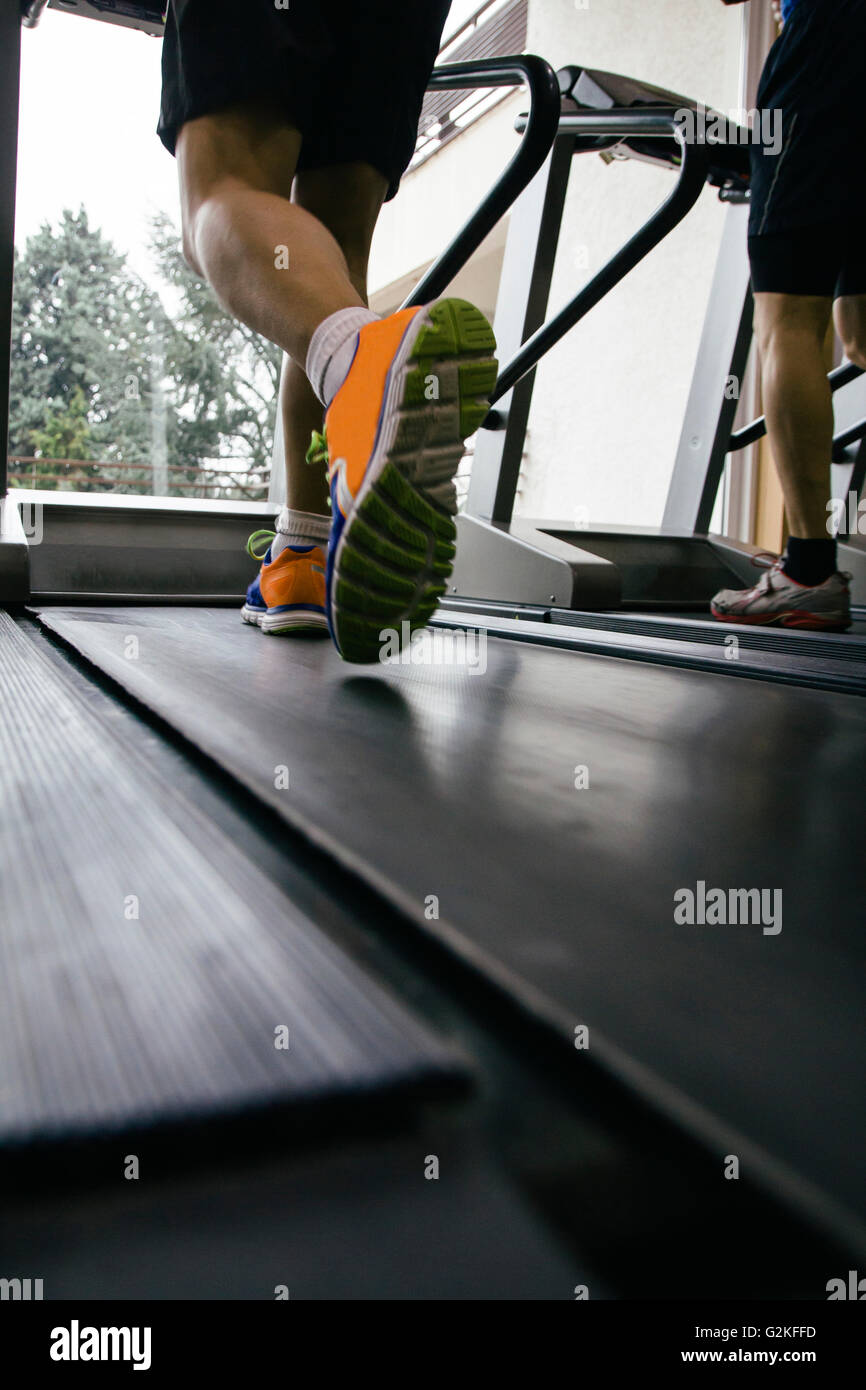 Legs of man running on a treadmill Stock Photo - Alamy