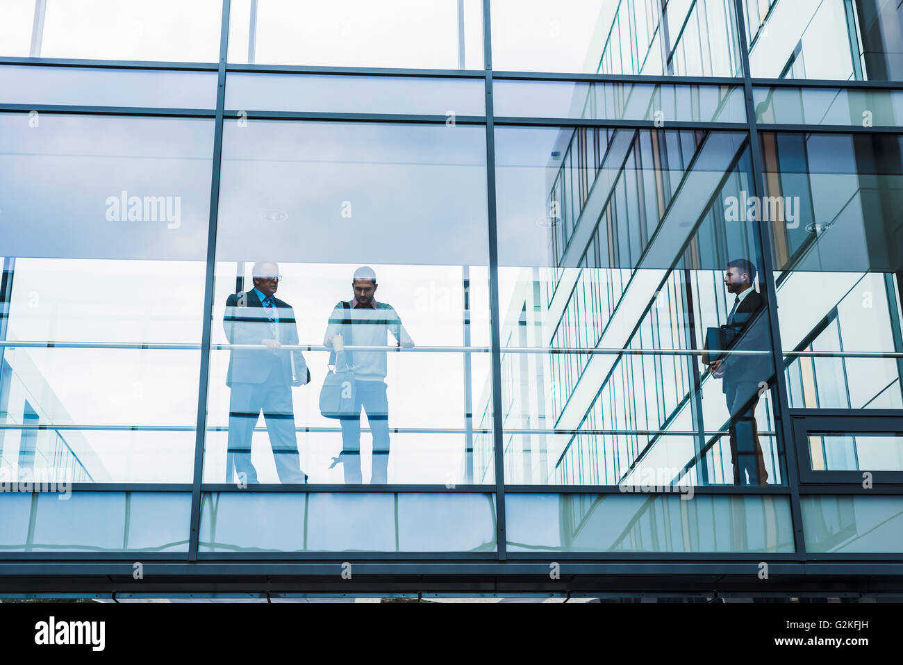 Three businessmen behind glass facade hi-res stock photography and ...