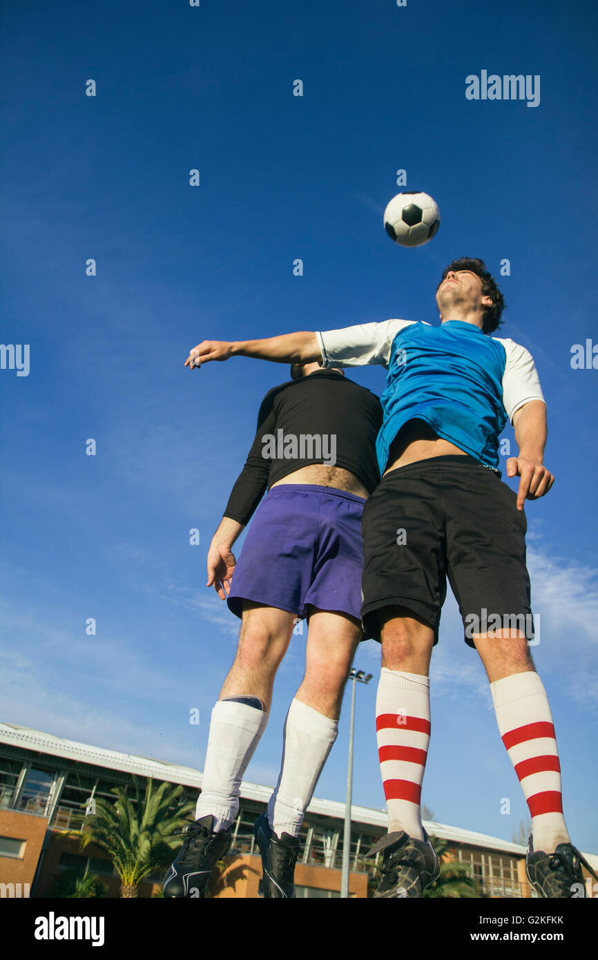 Two football players heading the ball jumping Stock Photo - Alamy