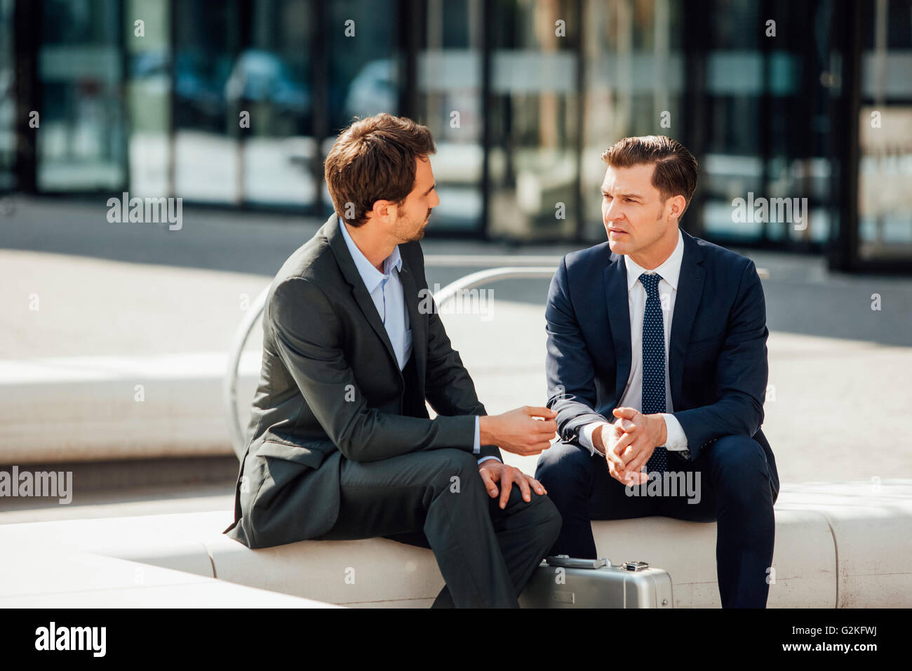 Two businessmen talking outside office building Stock Photo - Alamy