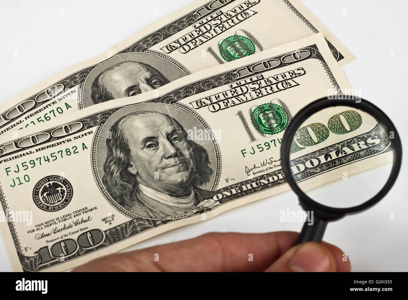 magnifying a dollar bill with a magnifying glass on white background ...