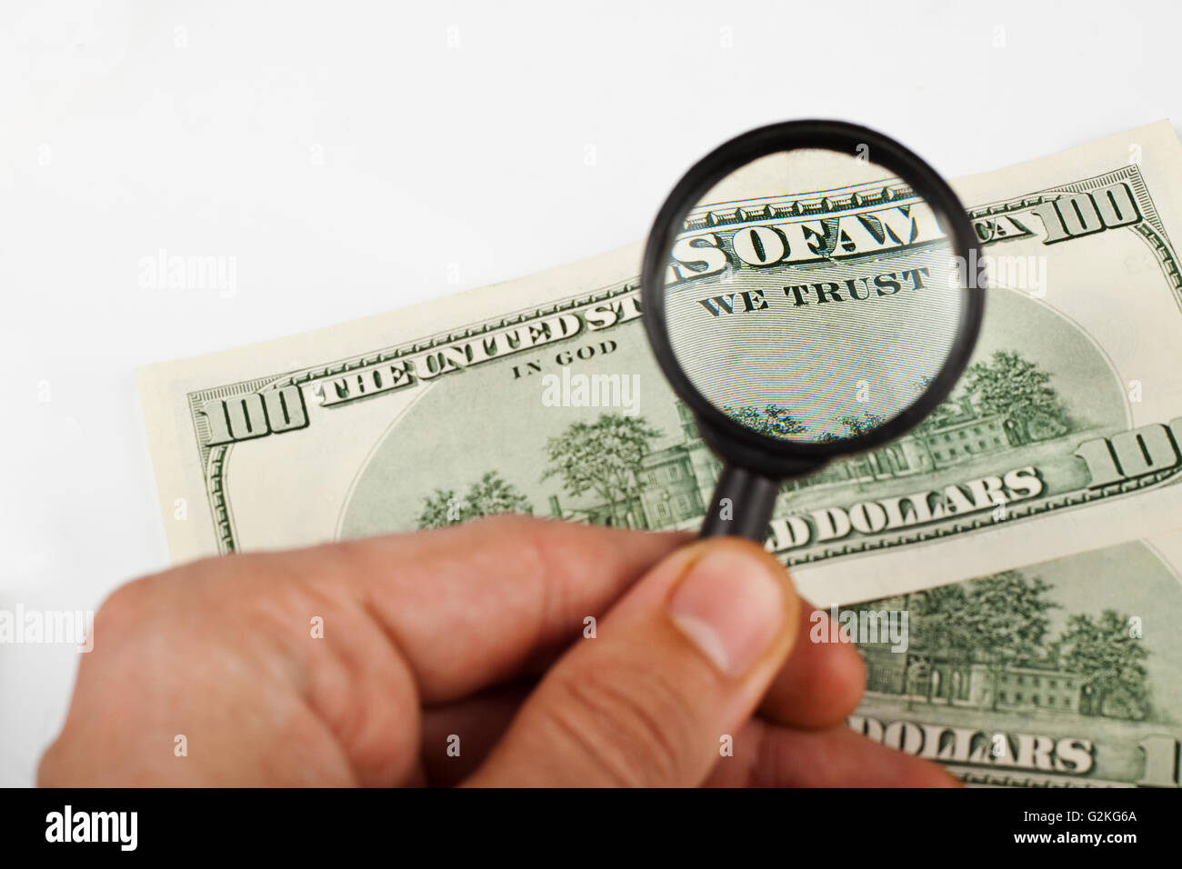 magnifying a dollar bill with a magnifying glass on white background ...