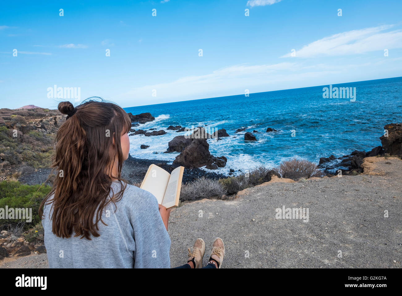 Young woman reading book at the sea Stock Photo - Alamy