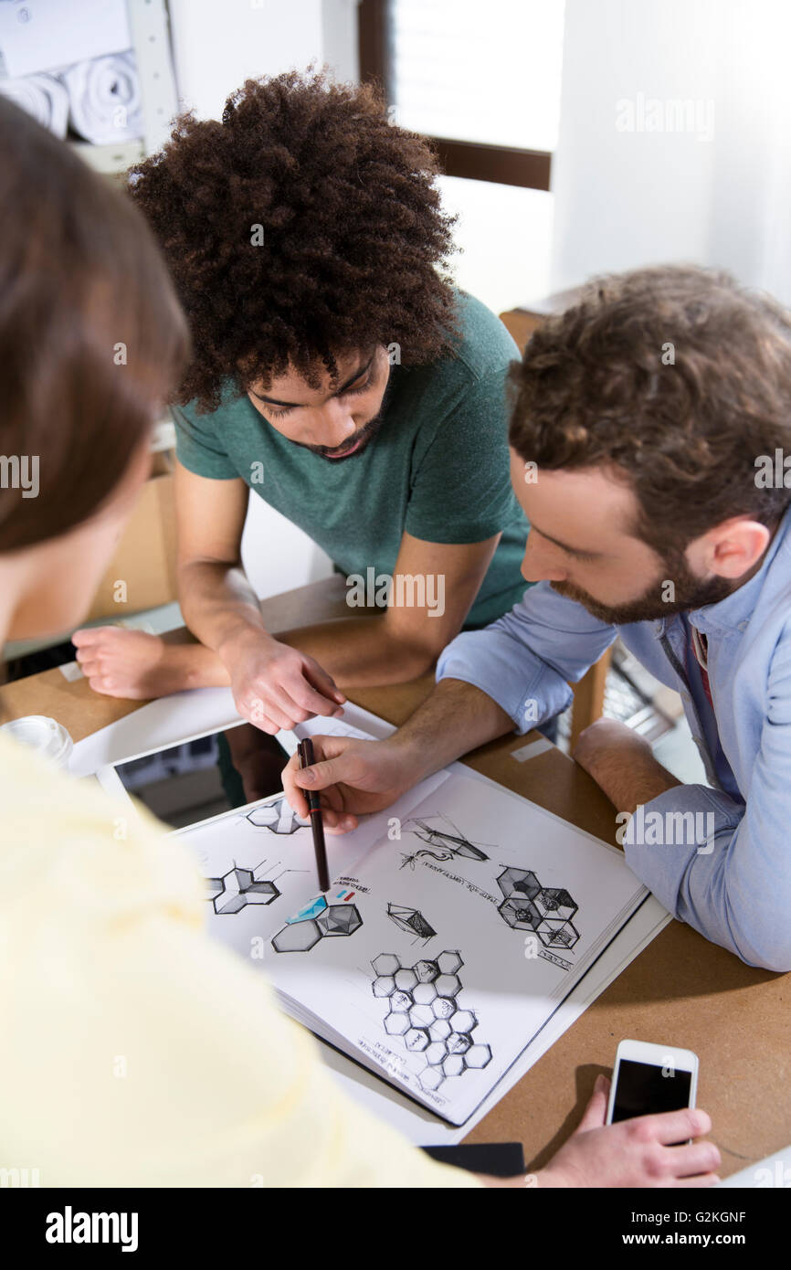 Three colleagues discussing draft in office Stock Photo - Alamy