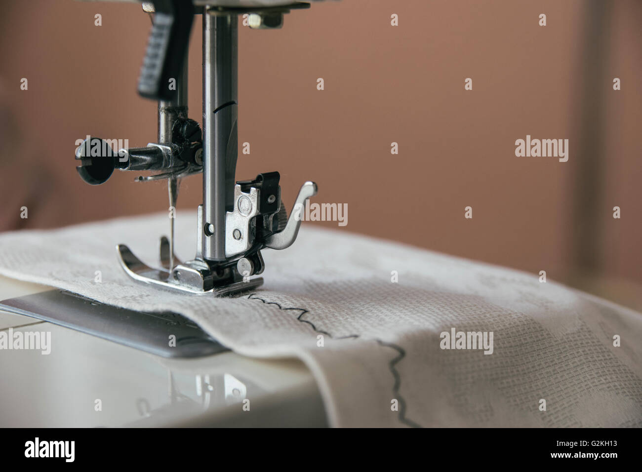 Sewing machine sewing on a white cloth Stock Photo - Alamy