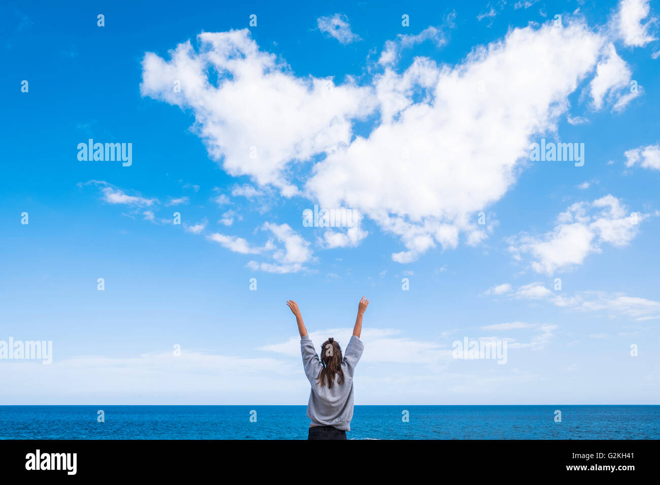 Young woman reaching with arms to the sky Stock Photo - Alamy