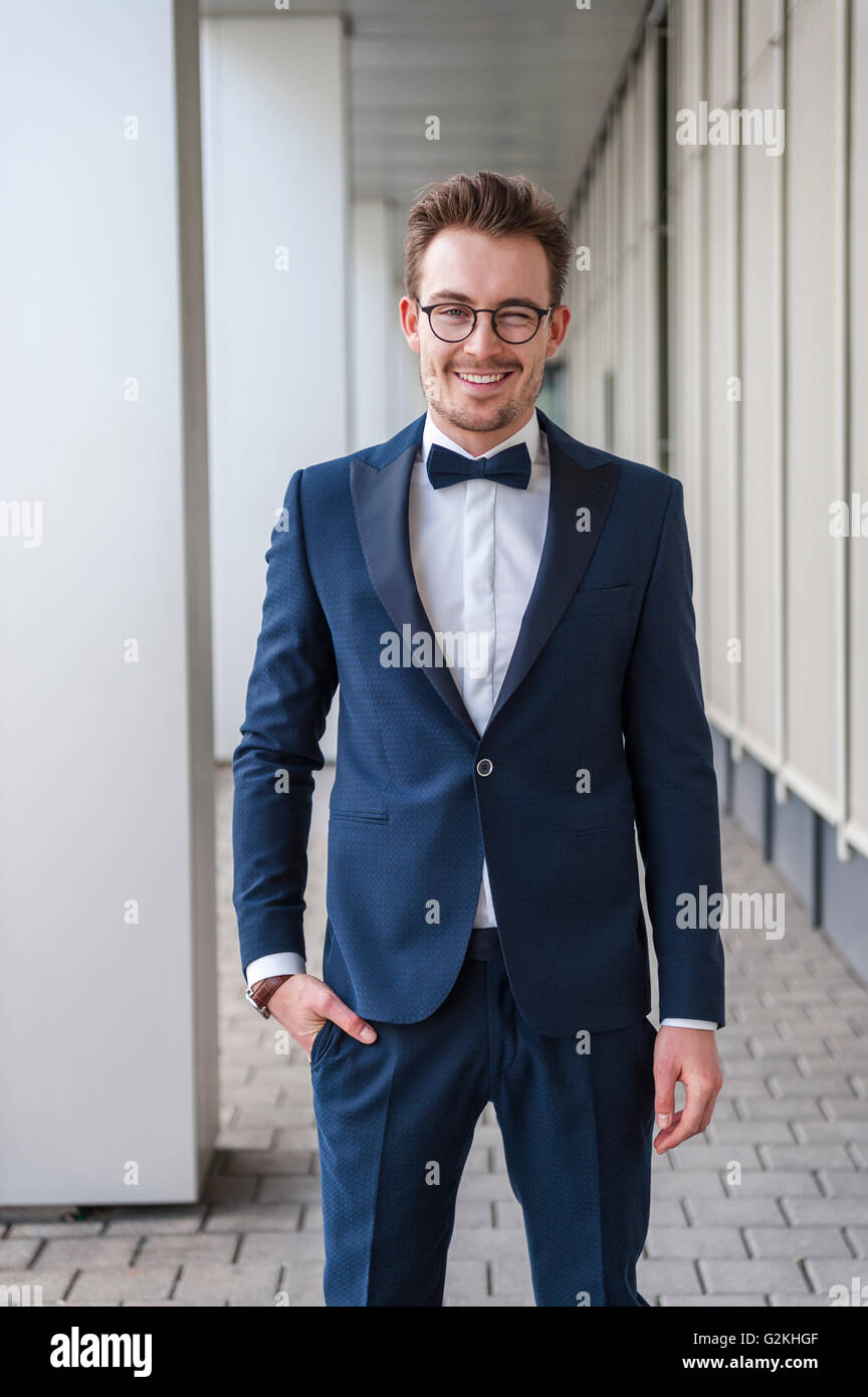 Portrait of winking young man wearing suit and bow tie Stock Photo - Alamy