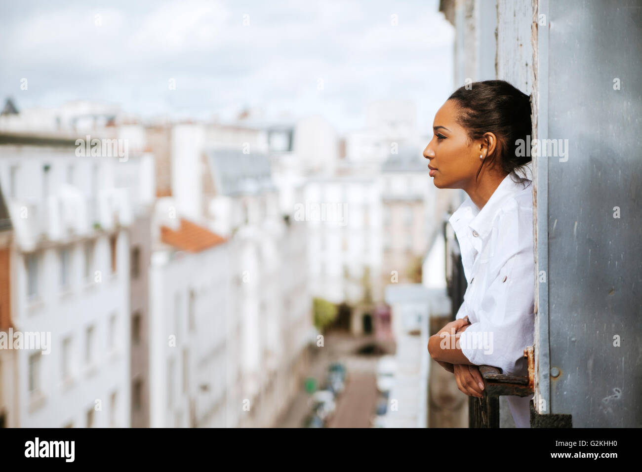 France, Paris, young woman at attic leaning out of window Stock Photo ...