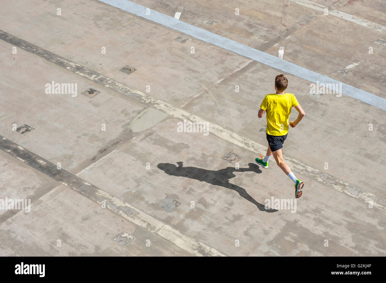 Young man jogging, concrete floor Stock Photo - Alamy