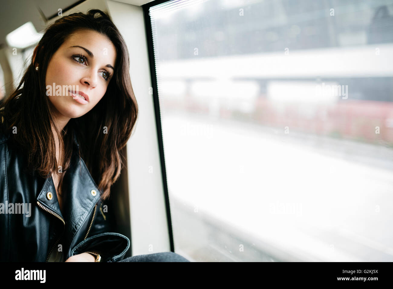 Young woman on train looking out of window Stock Photo - Alamy