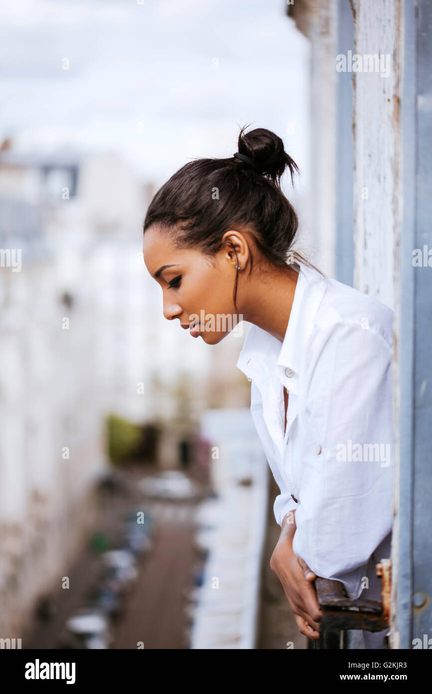 France, Paris, young woman leaning out of window looking down Stock ...