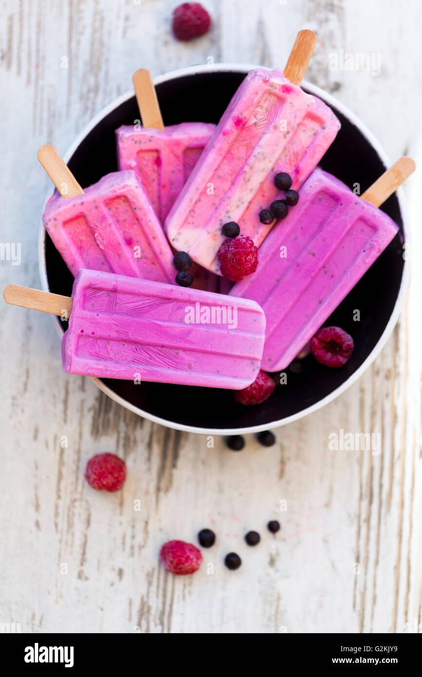 Plate with homemade blueberry ice lollies and raspberry ice lollies ...