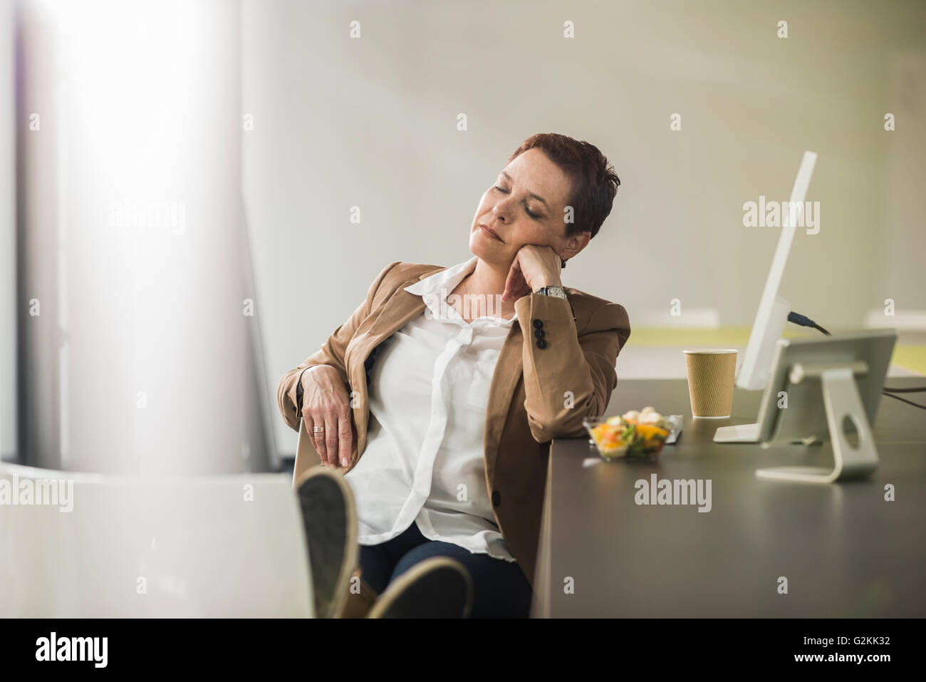 Female senior manager sitting in office, power nap Stock Photo - Alamy