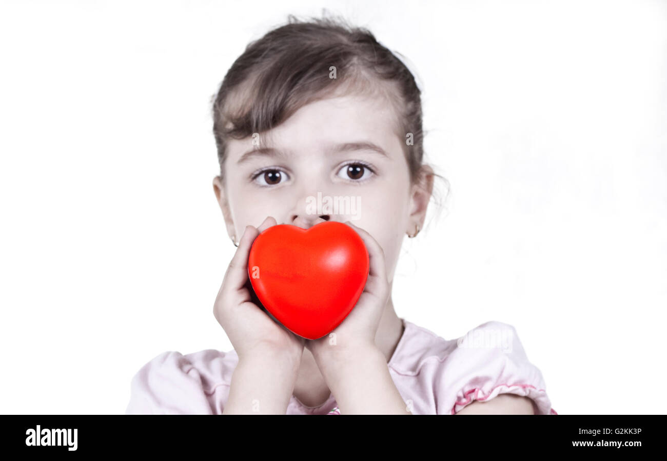 young child holding a red heart on white background Stock Photo - Alamy