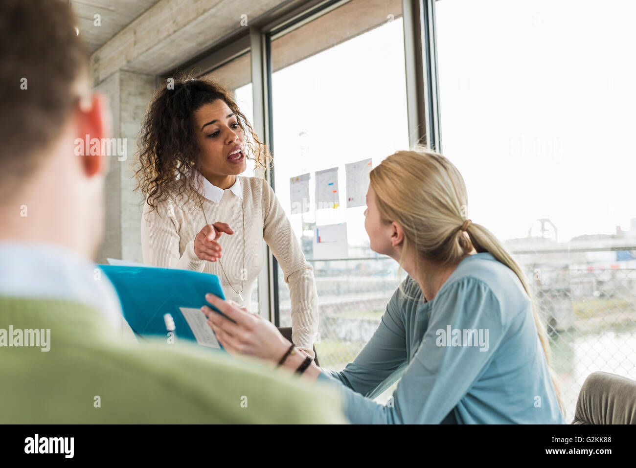 Three colleagues talking in office Stock Photo - Alamy