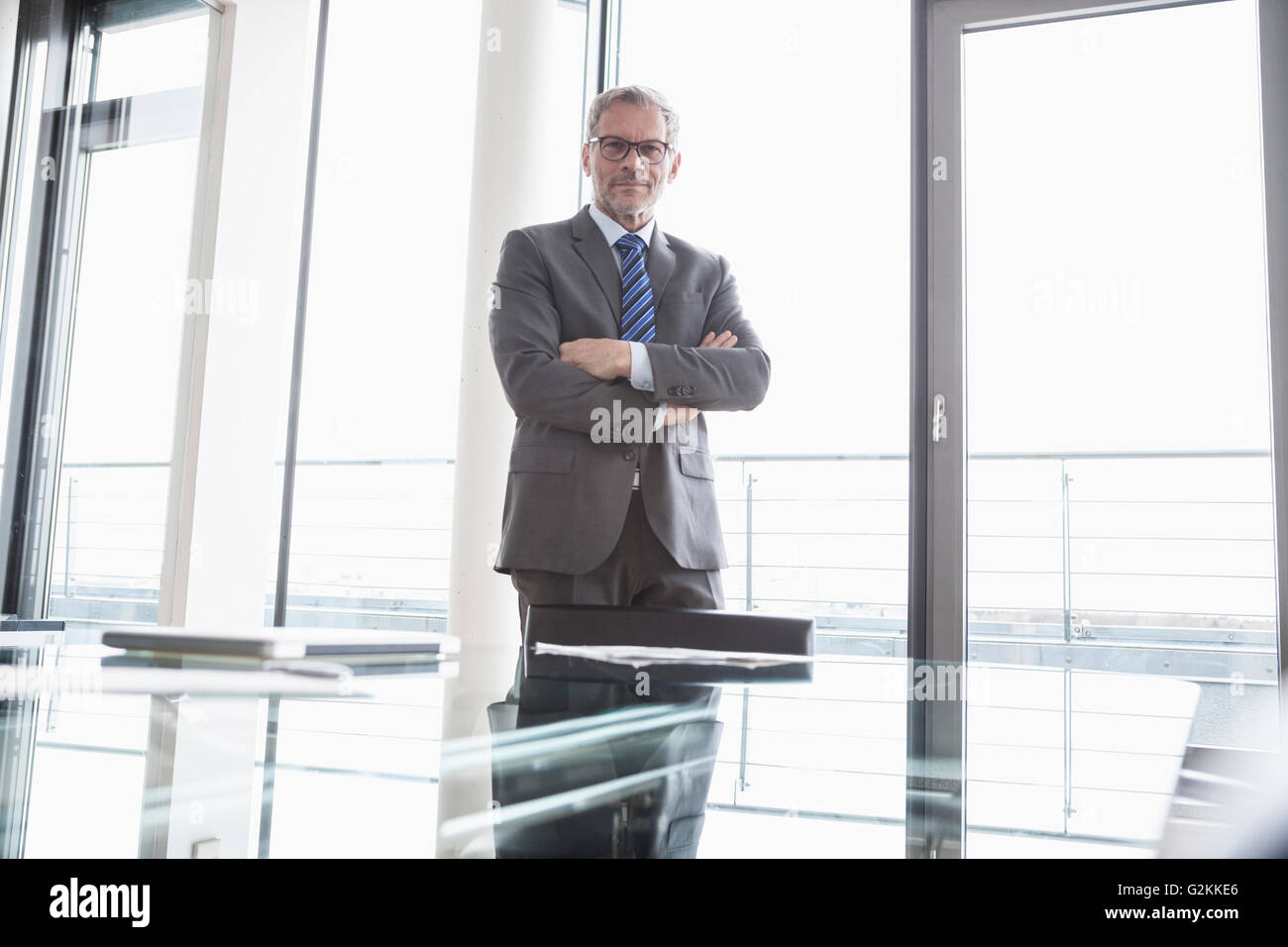 Successful manager standing in conference room with arms crossed Stock ...