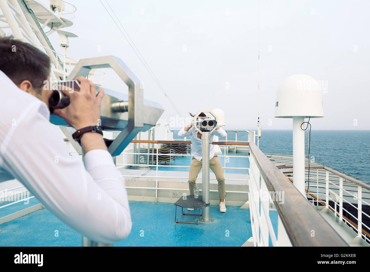 Two young men on a ship watching each other through telescopes Stock ...