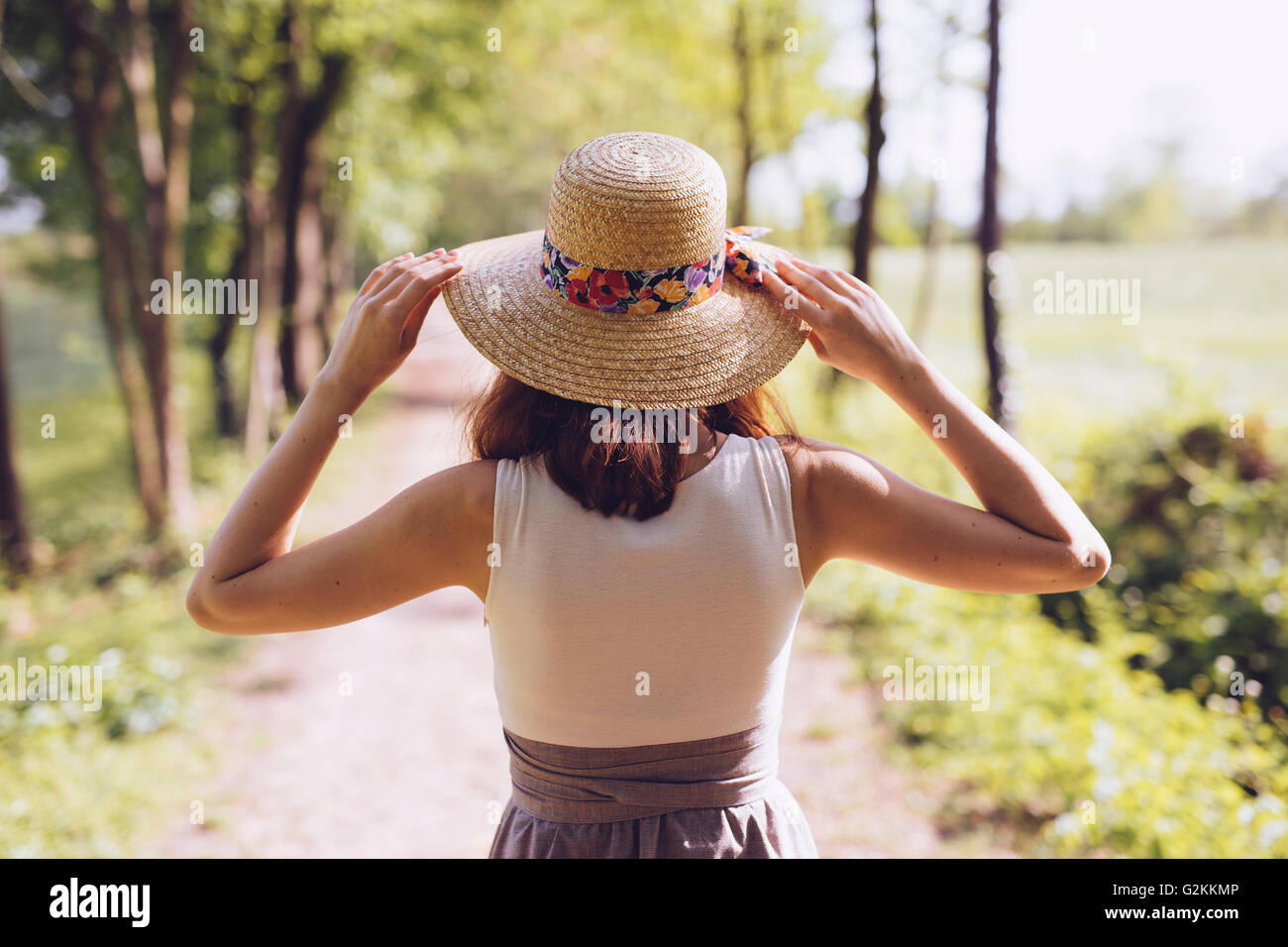Back view of young woman wearing straw hat Stock Photo - Alamy