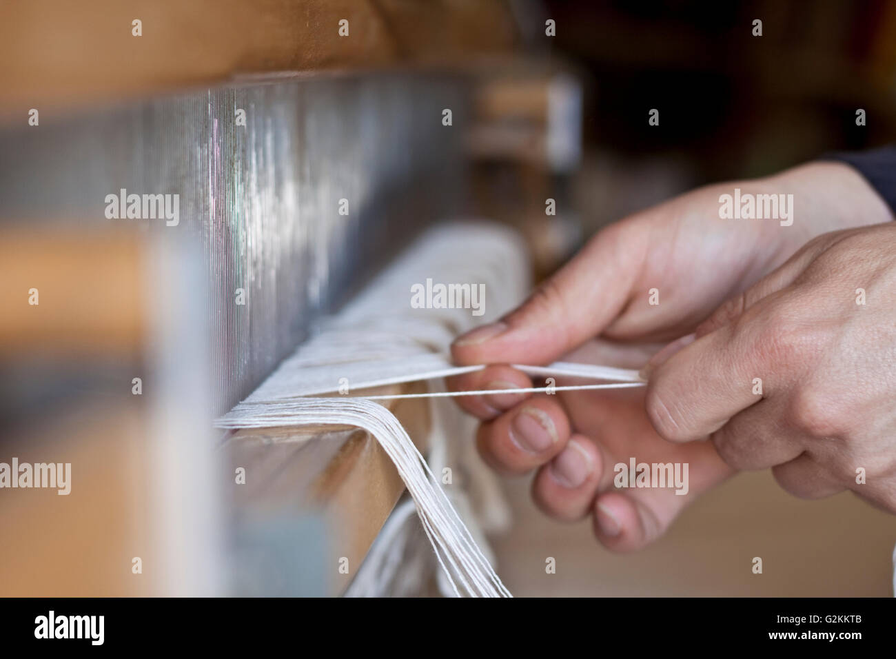hand working with white strings in the txtile industry Stock Photo - Alamy