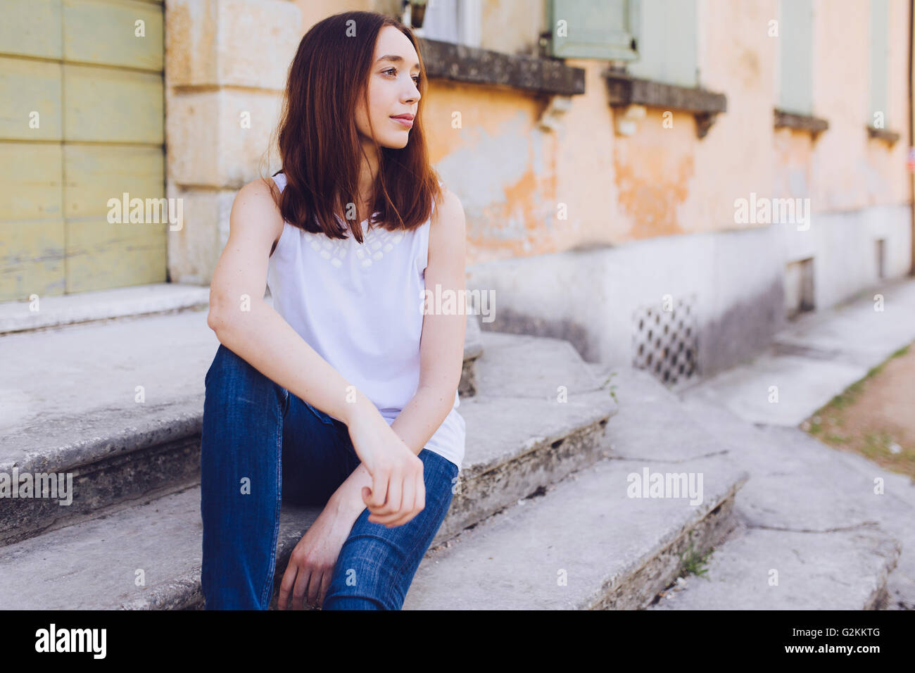 Woman sitting on steps Stock Photo - Alamy