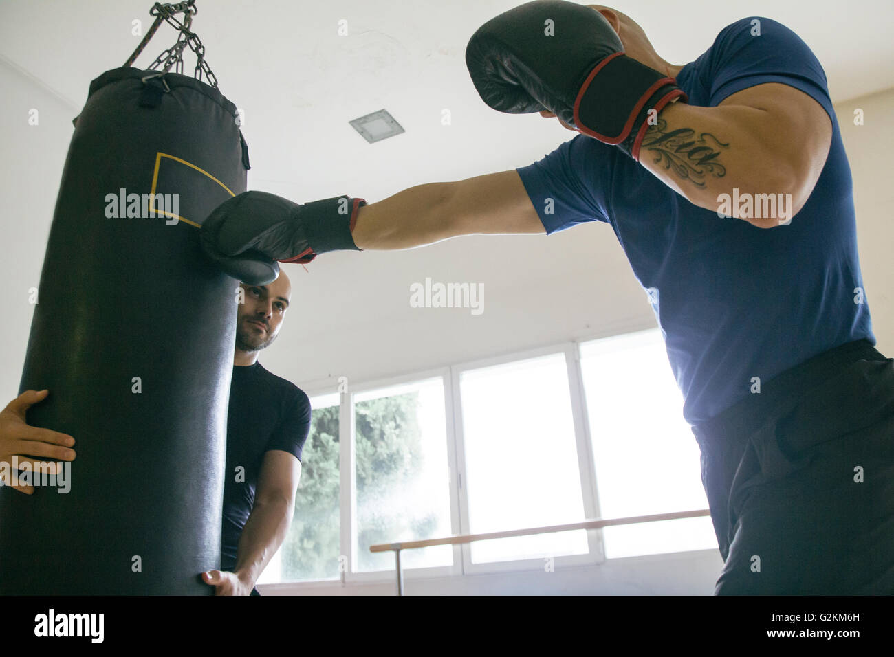 Boxer hitting a punching bag held by a training partner Stock Photo - Alamy