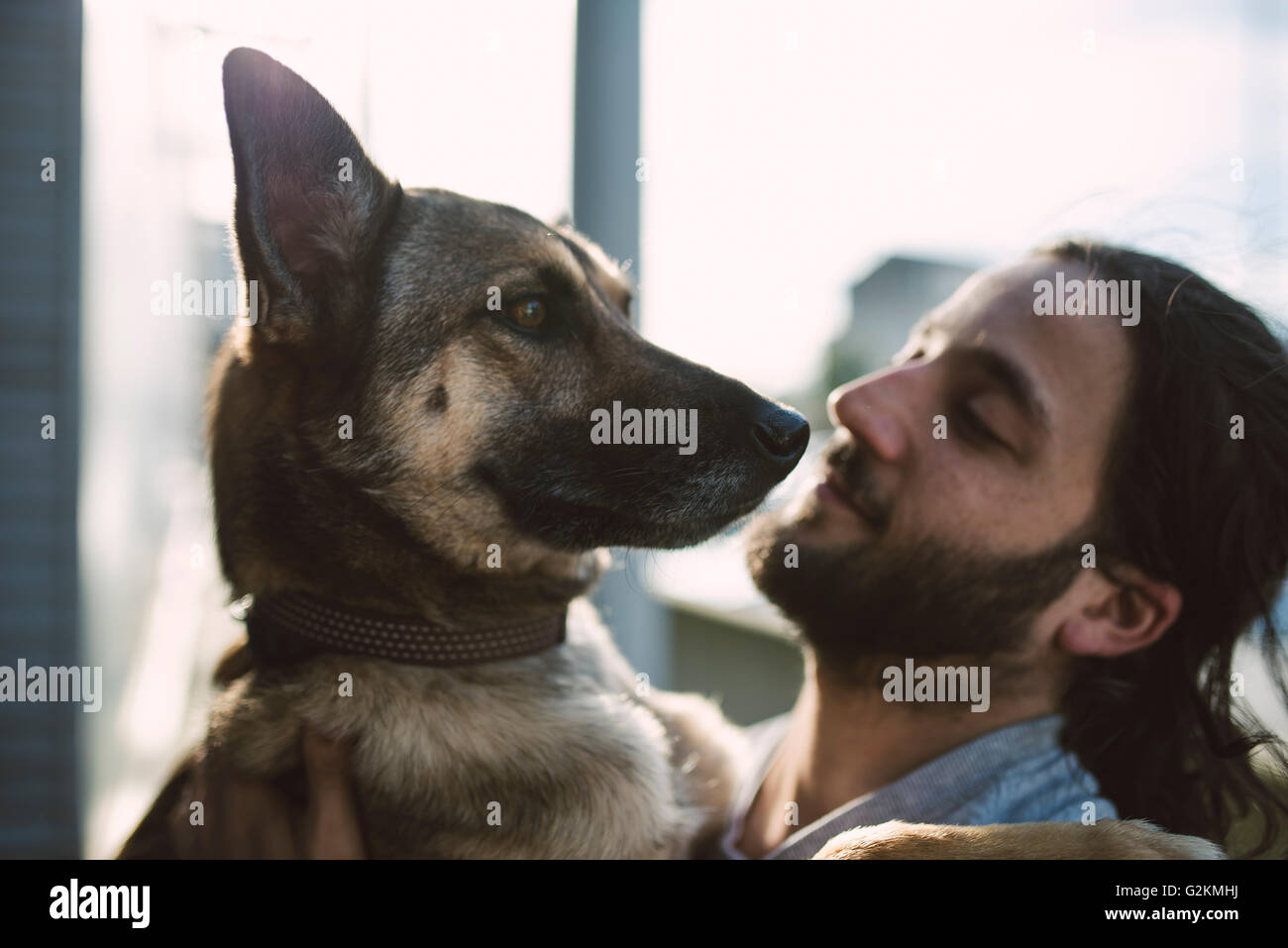 Young man holding dog outdoors Stock Photo - Alamy