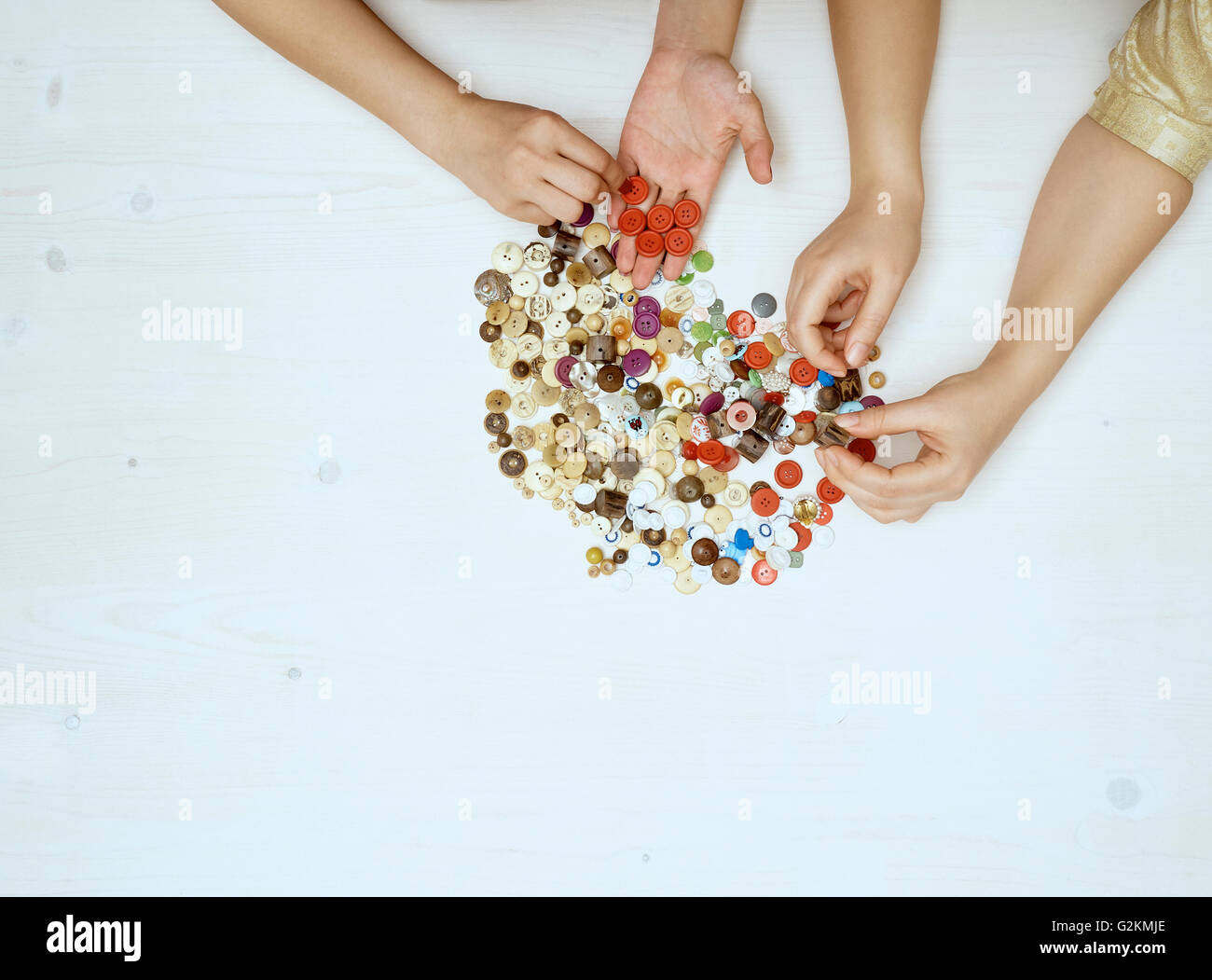 Hands sorting buttons Stock Photo - Alamy