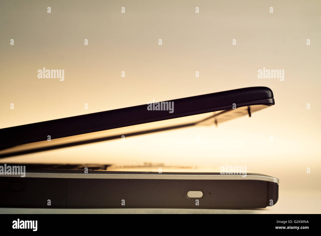 laptop closeup fading in the orange lit background Stock Photo - Alamy