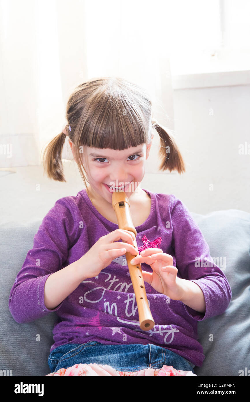 Little girl playing recorder at home Stock Photo - Alamy