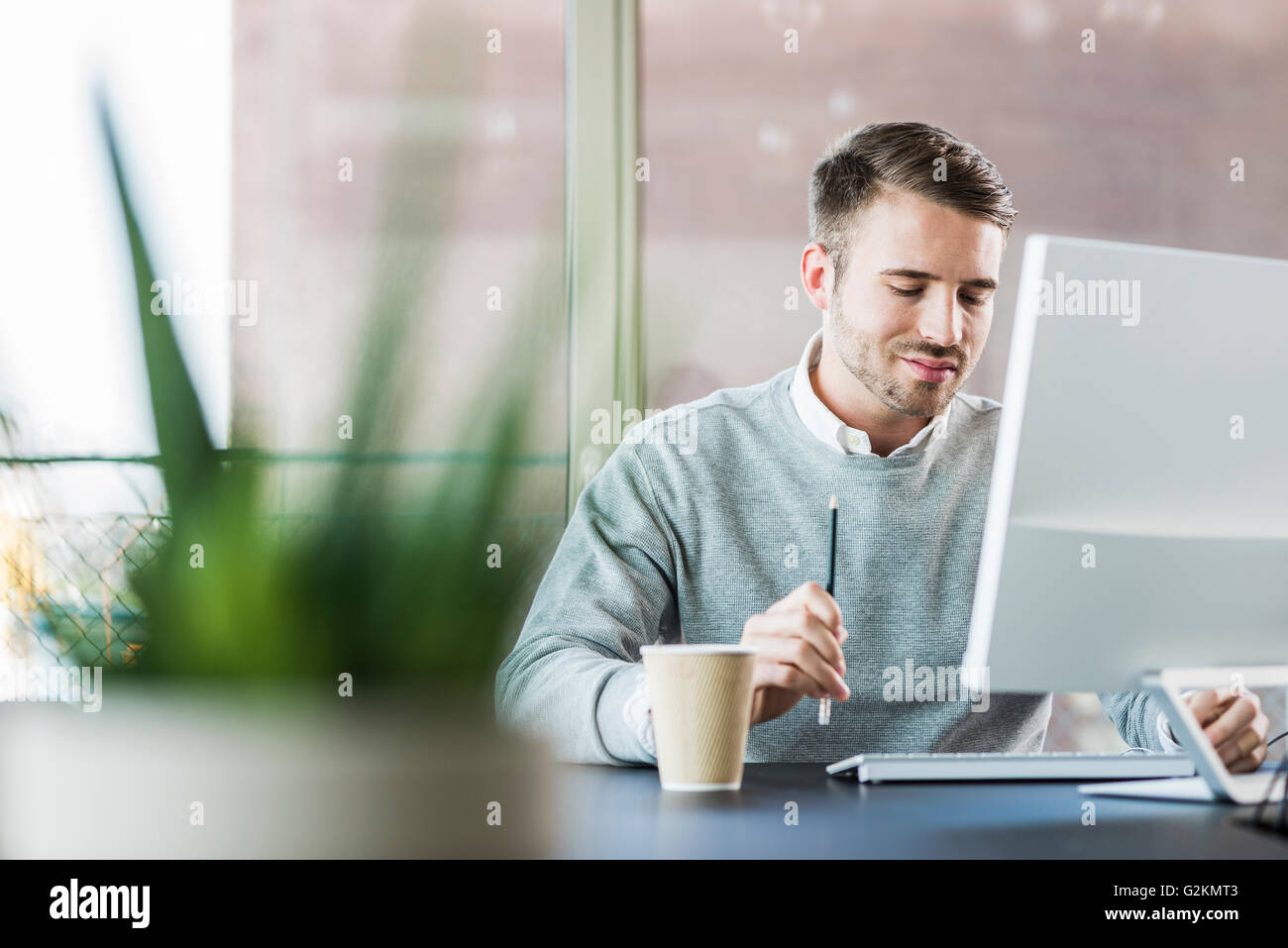 Young man at office desk Stock Photo - Alamy