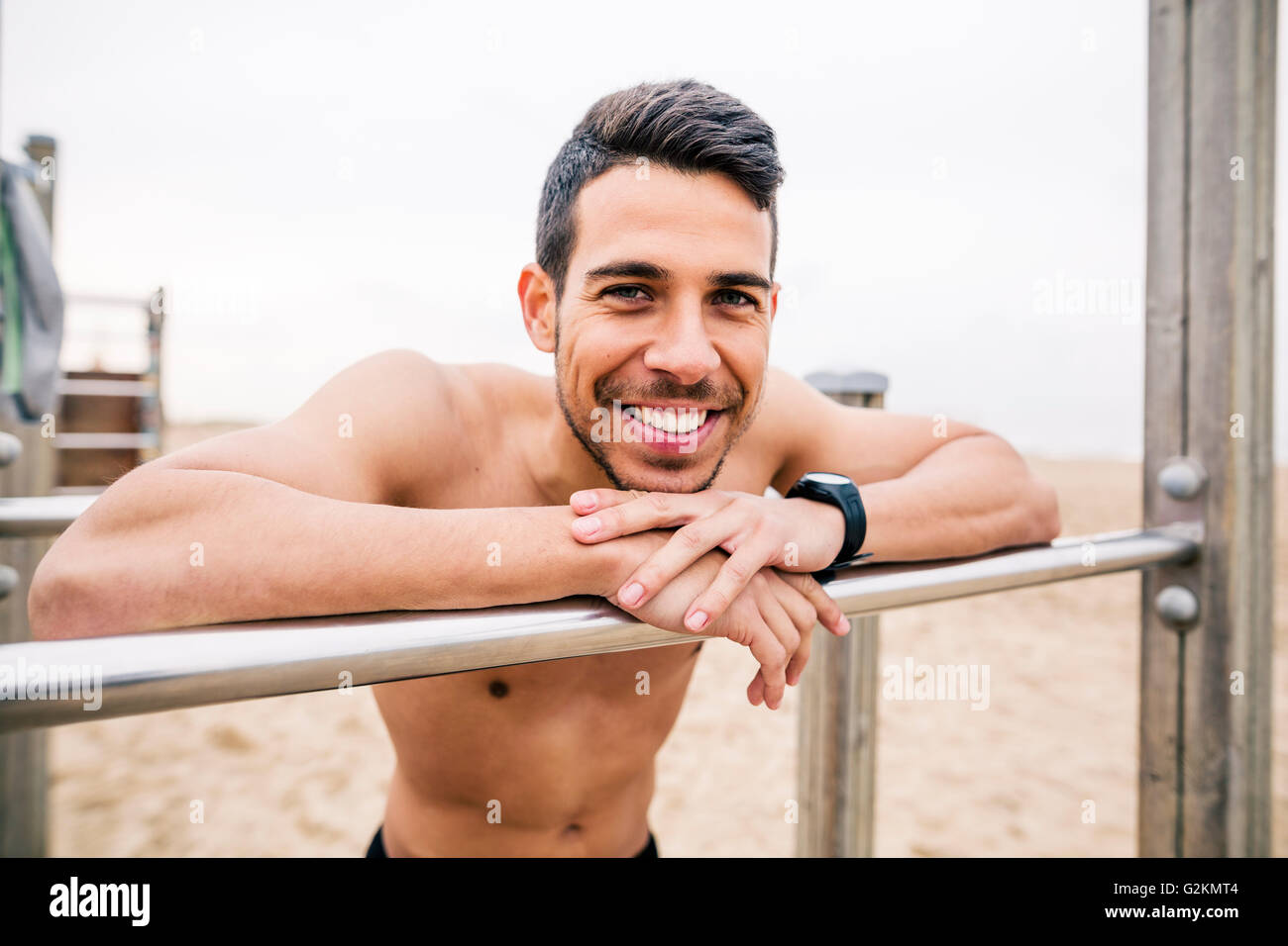 Portrait of smiling athlete on bars on the beach Stock Photo - Alamy