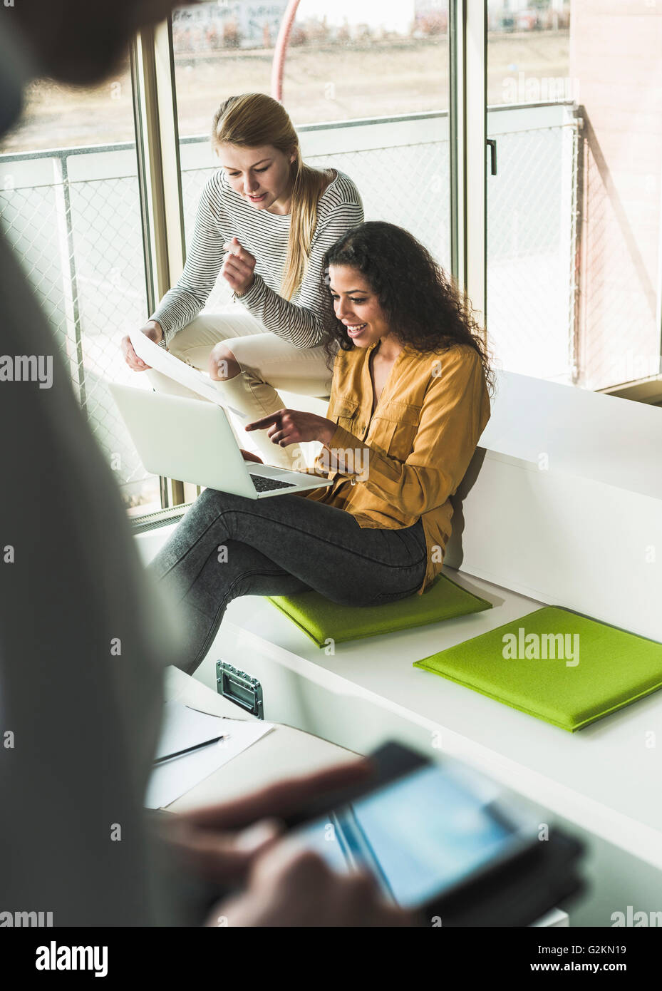 Two women in office using laptop Stock Photo - Alamy
