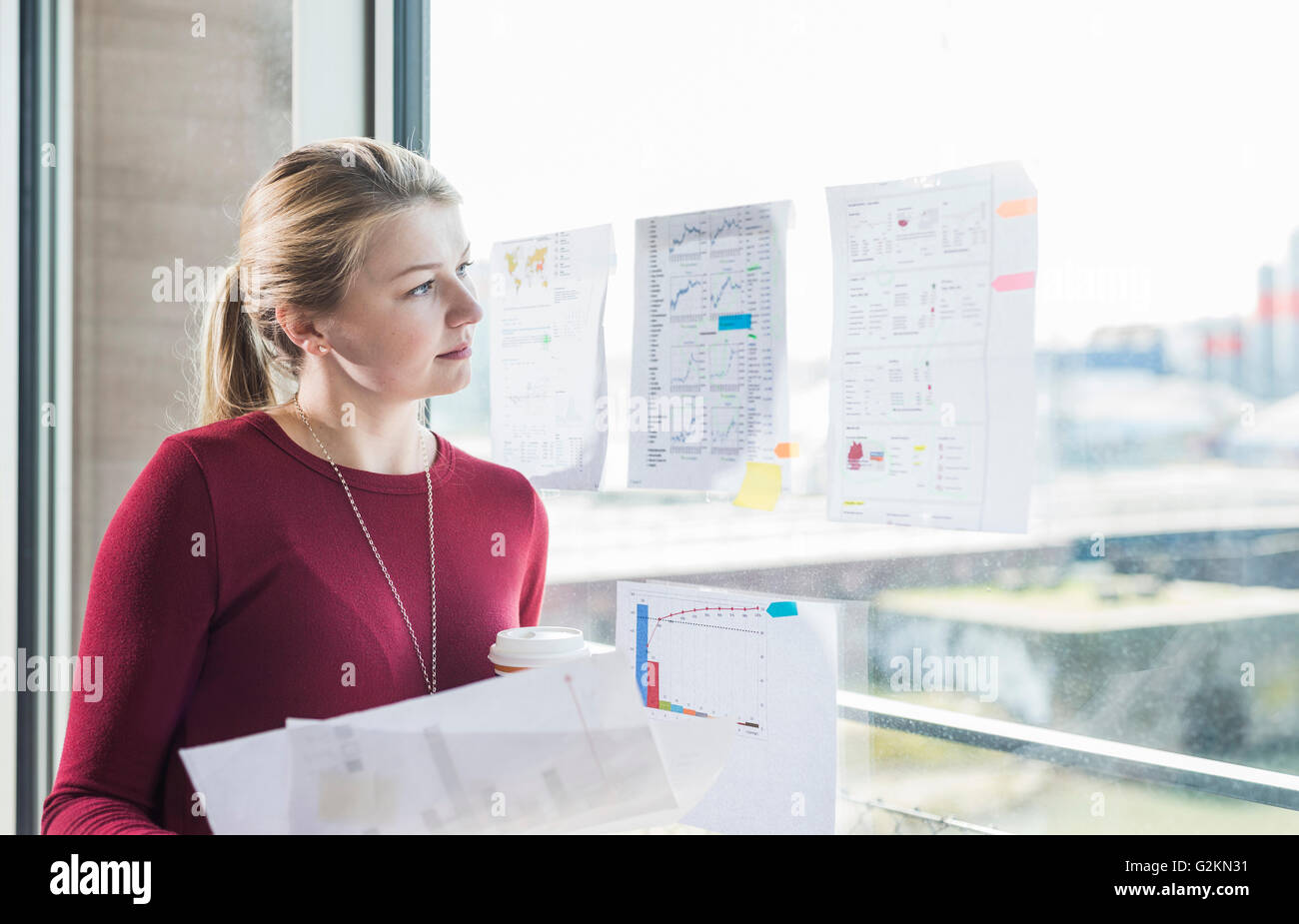 Young woman looking at graphs on the window Stock Photo - Alamy