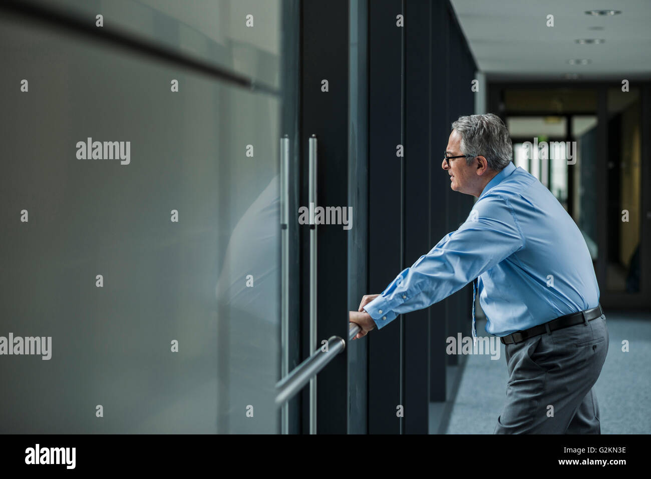 Senior businessman looking out of window Stock Photo - Alamy