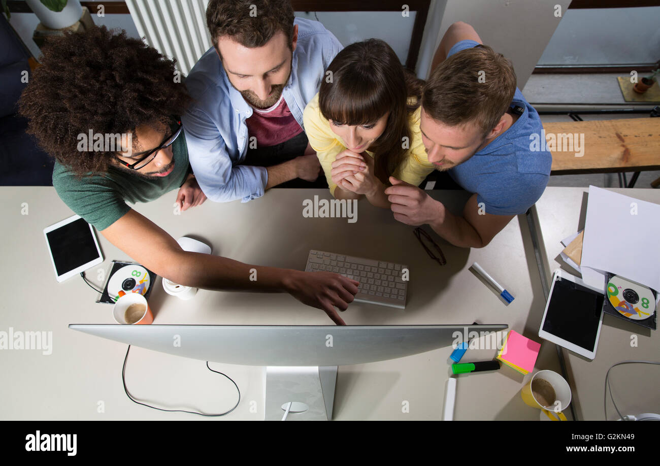 Team of creative professionals sitting around computer screen Stock ...