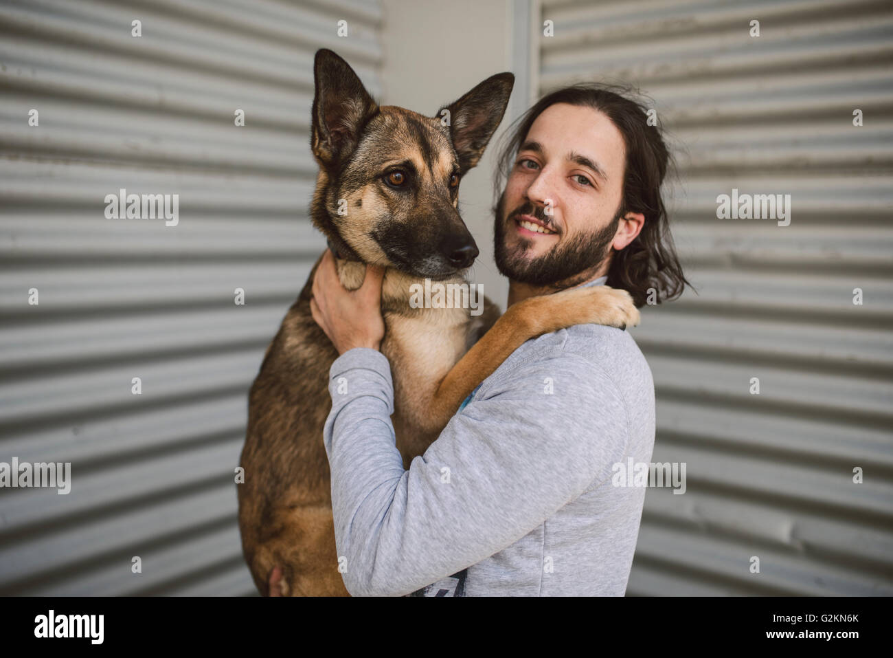 Portrait of young man holding dog Stock Photo - Alamy