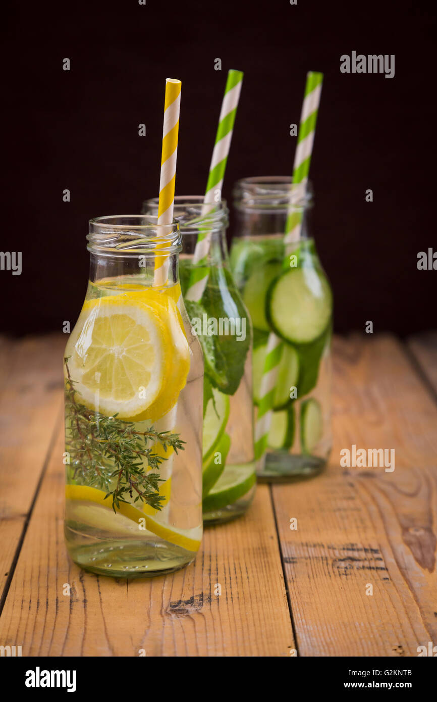 Three glass bottles of table water flavored with different fruits and ...