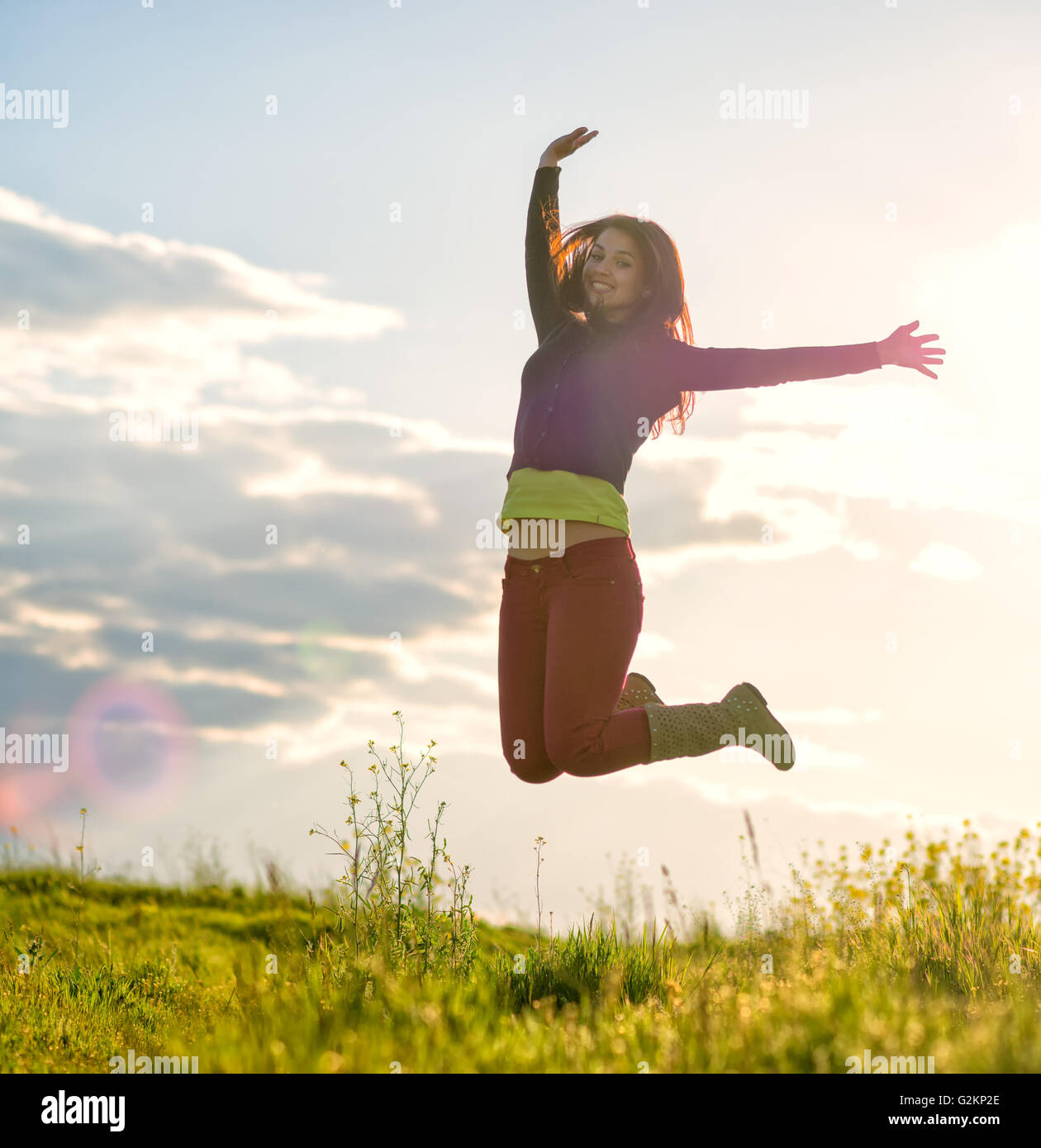 young girl jumping in the sunset light Stock Photo - Alamy
