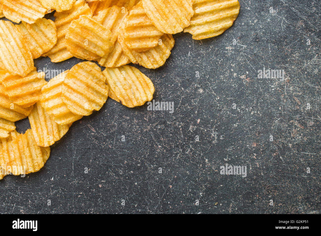 Crinkle cut potato chips on table. Tasty spicy potato chips Stock Photo ...