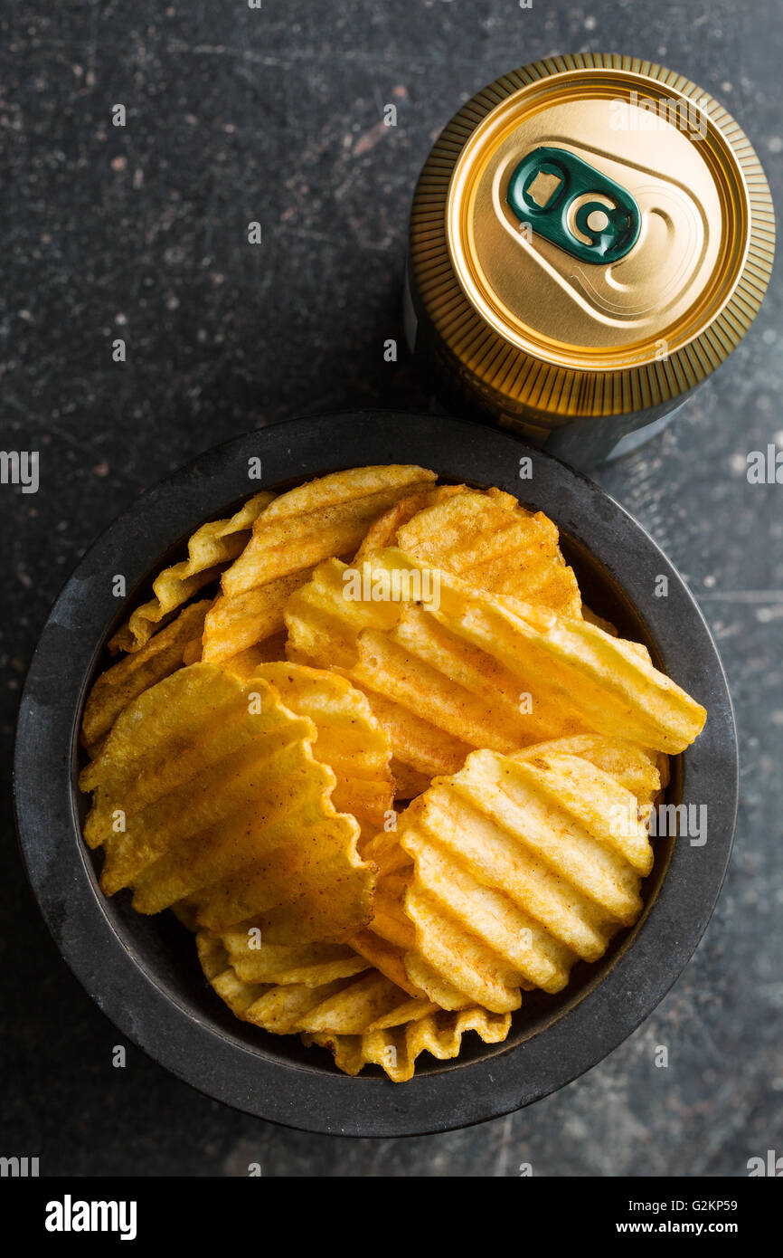 Crinkle cut potato chips on table. Tasty spicy potato chips with beer ...