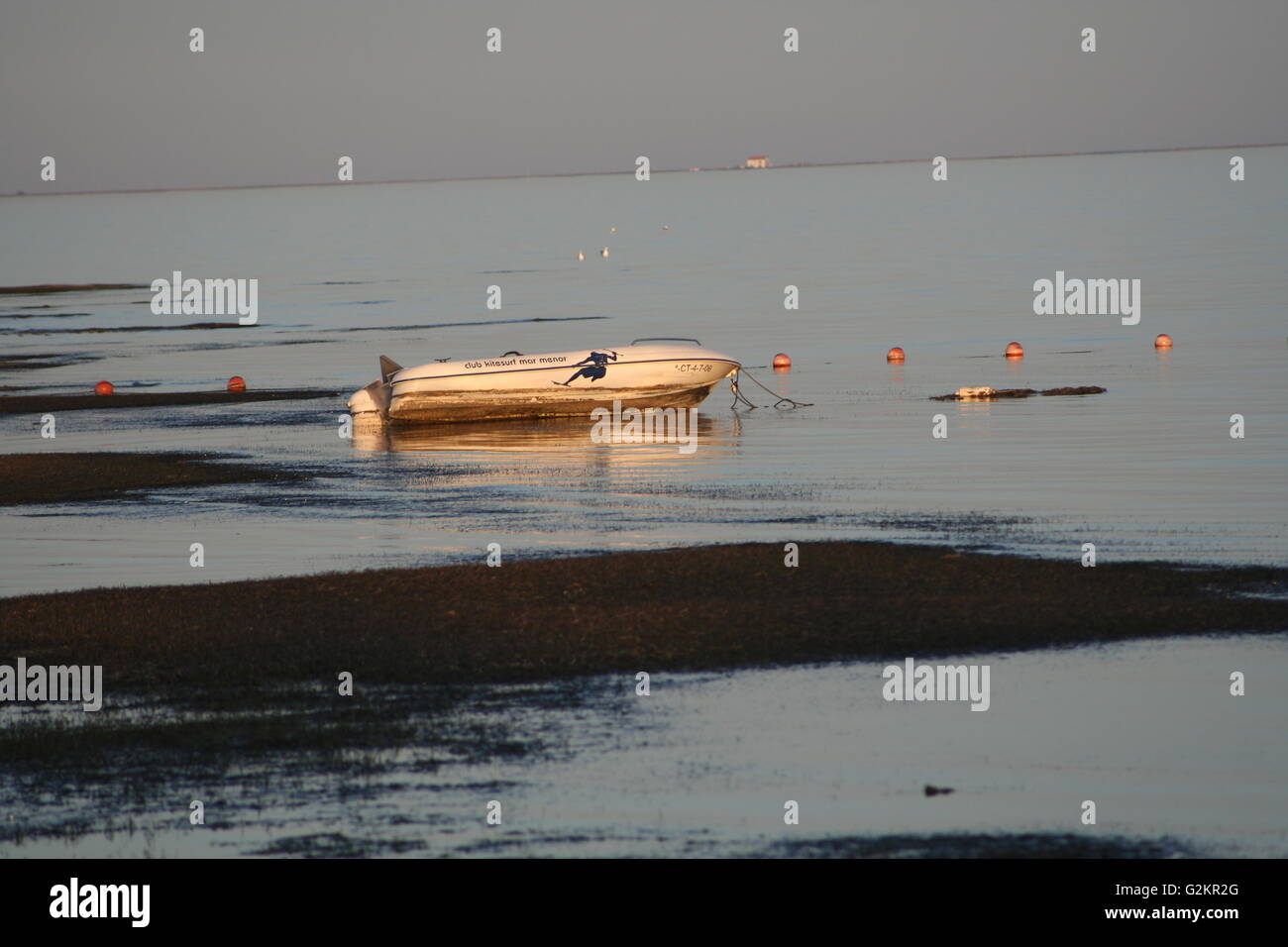 Boat in shallow water at the beach Stock Photo - Alamy
