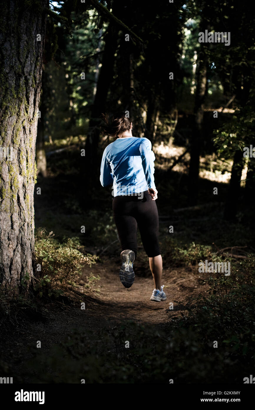Woman Running on Trail in Woods Stock Photo - Alamy