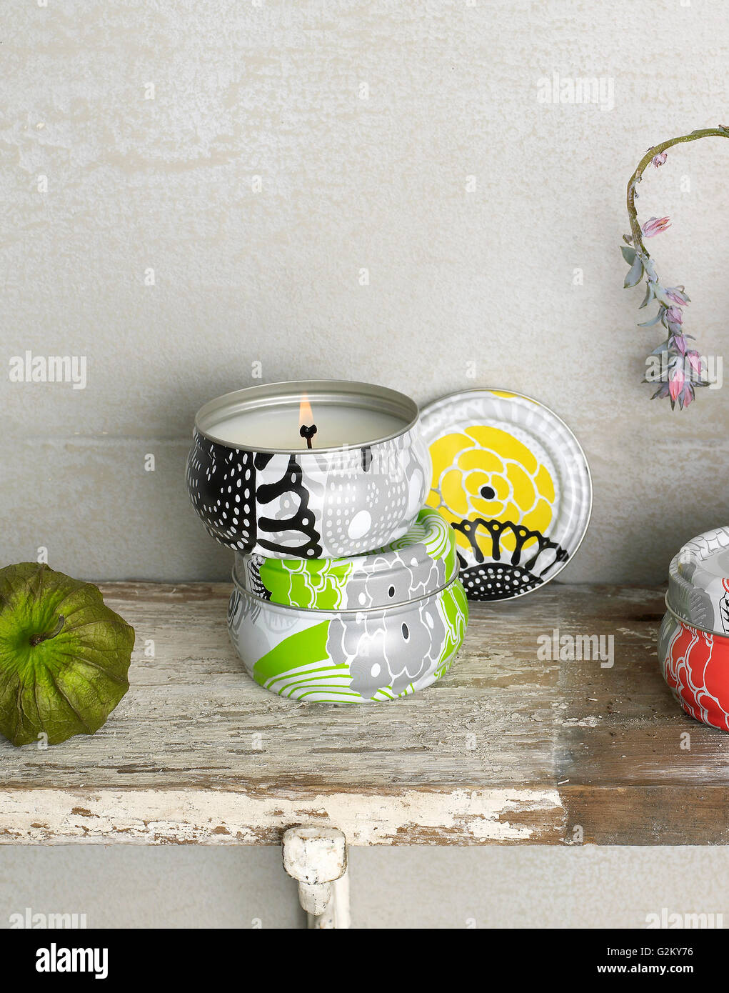 Lit Candle in Colorful Tin Container Stock Photo - Alamy