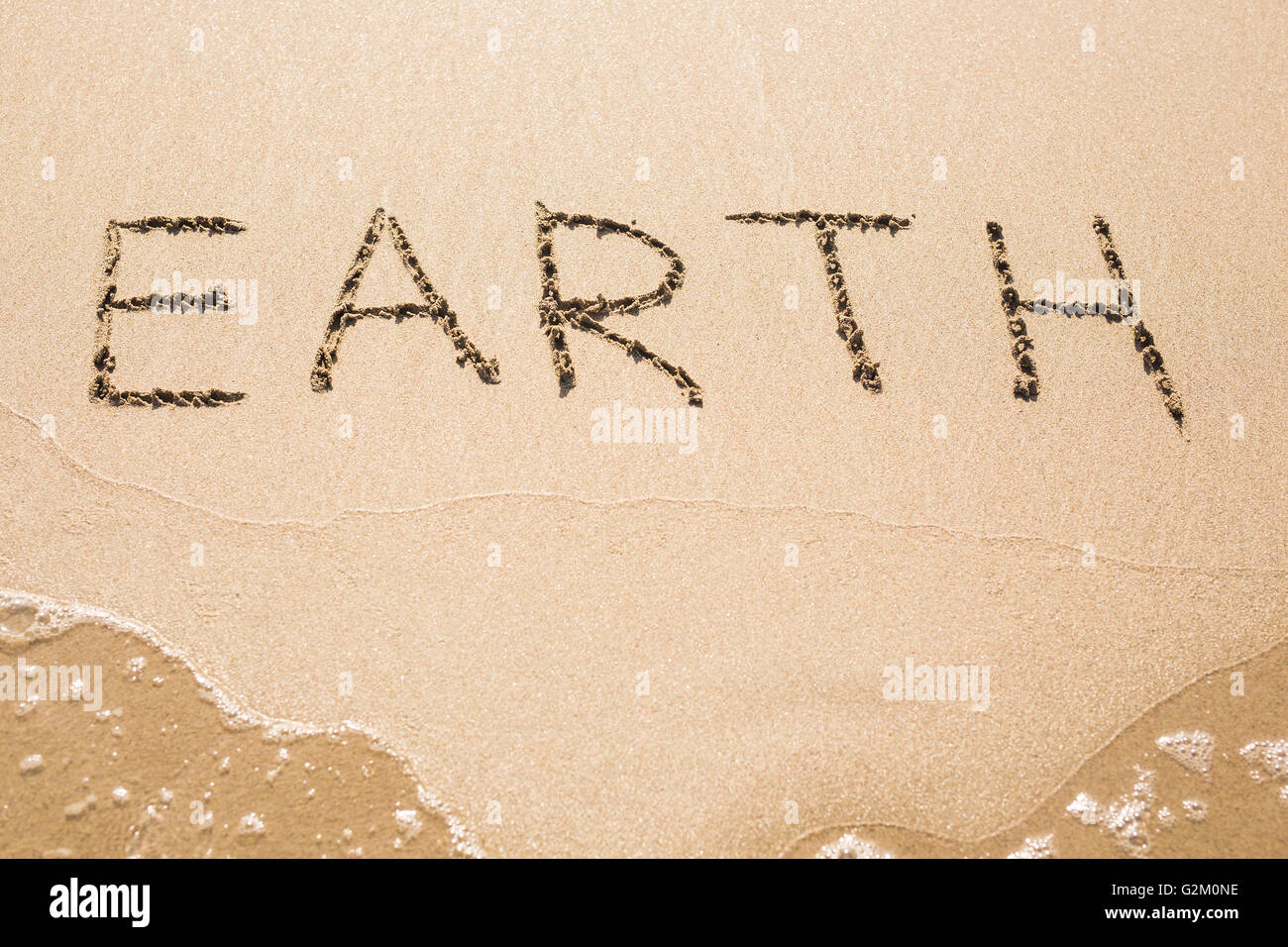 earth text on the sand Stock Photo - Alamy