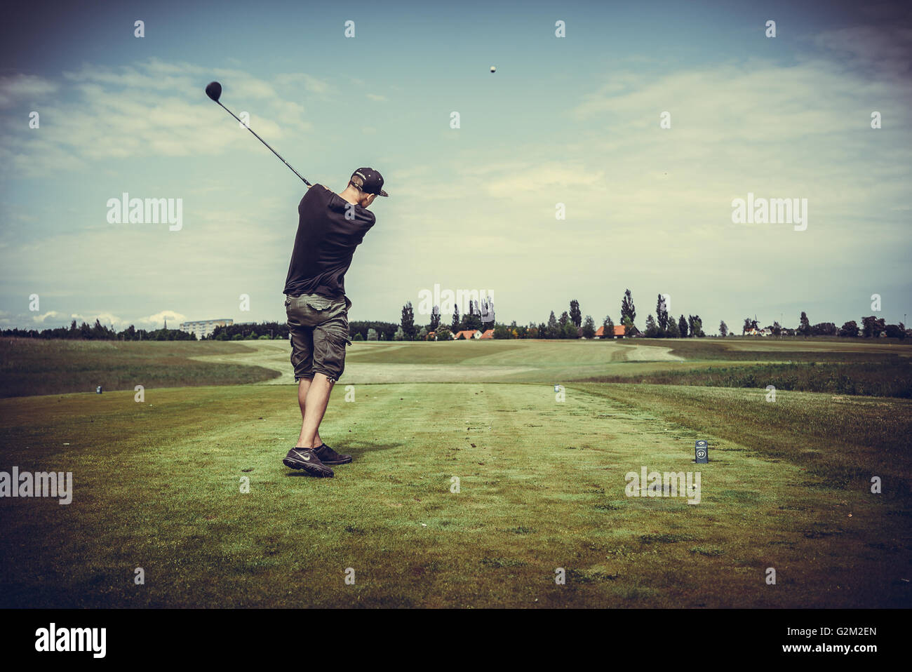 golfer taking a hit. ball in mid air Stock Photo - Alamy