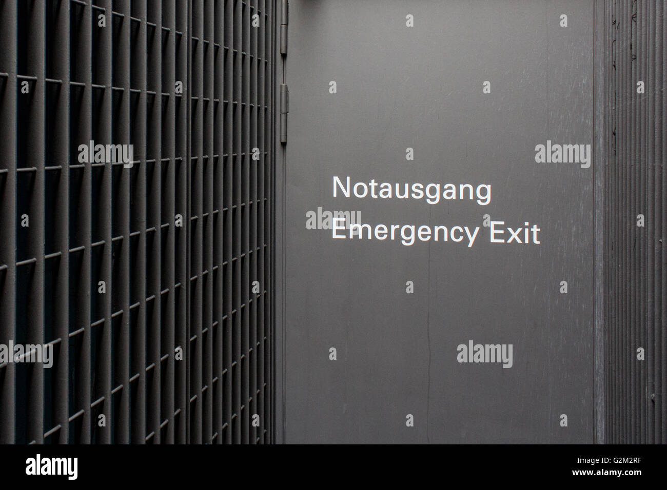 emergency exit door - german and english text on grey door Stock Photo ...