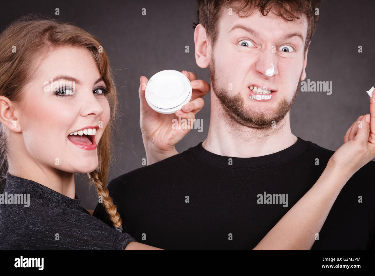 Protection and skincare. Stubborn girlfriend trying to apply cream on ...