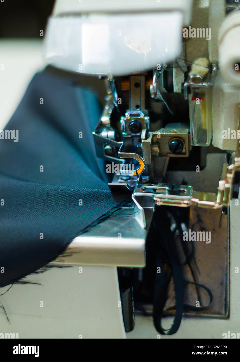 Sewing machine close up, needle making the stitches and fabric press on ...