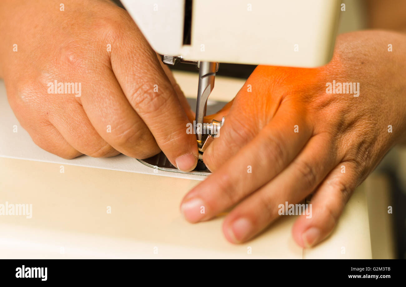 Close up of hands making some arrangement to sewing machine, needle and ...
