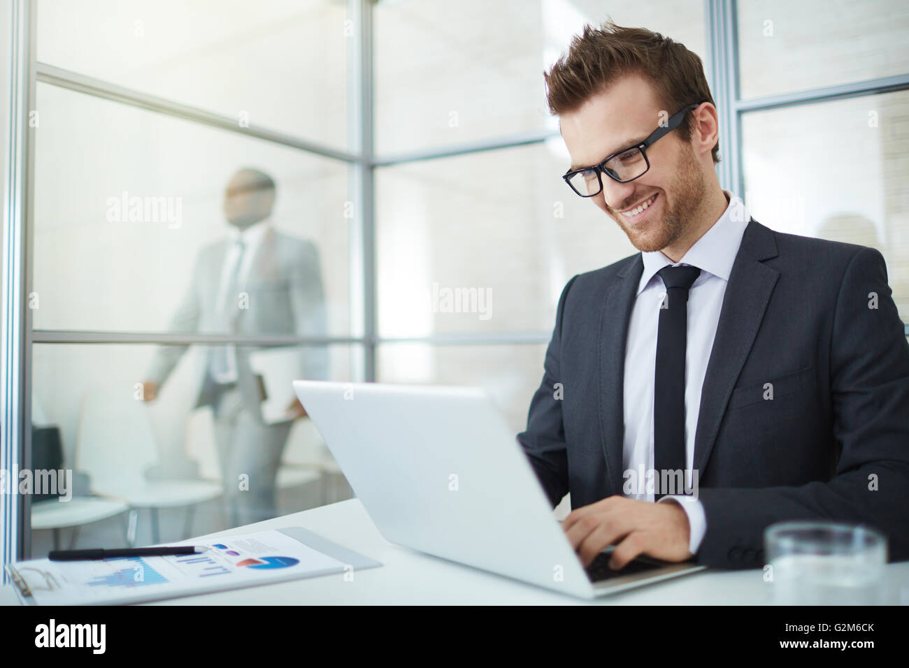 Young man in formalwear typing in office Stock Photo - Alamy